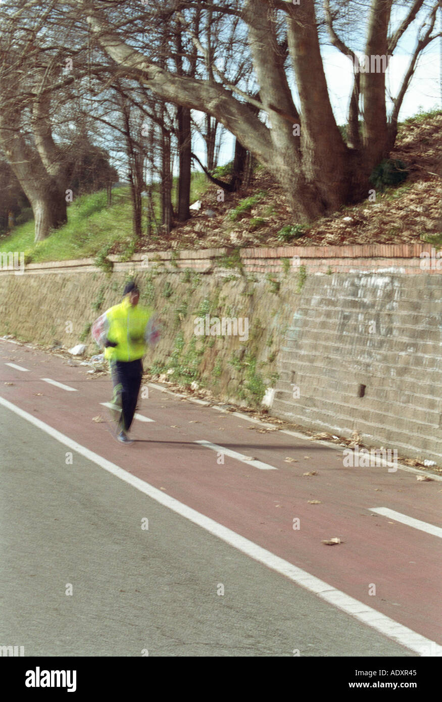 man running with yellow high visibility jacket on cycle path movement ...
