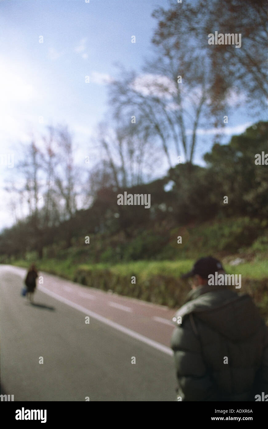 two people walking towards each other along tree covered cycle path ...