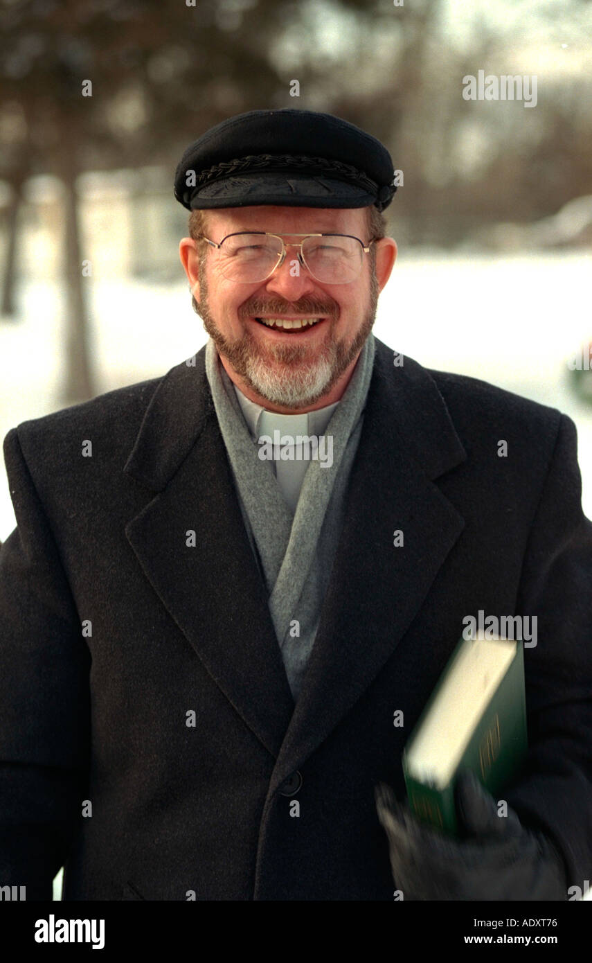 Minister age 48 smiling with bible in hand at cemetery after funeral ...