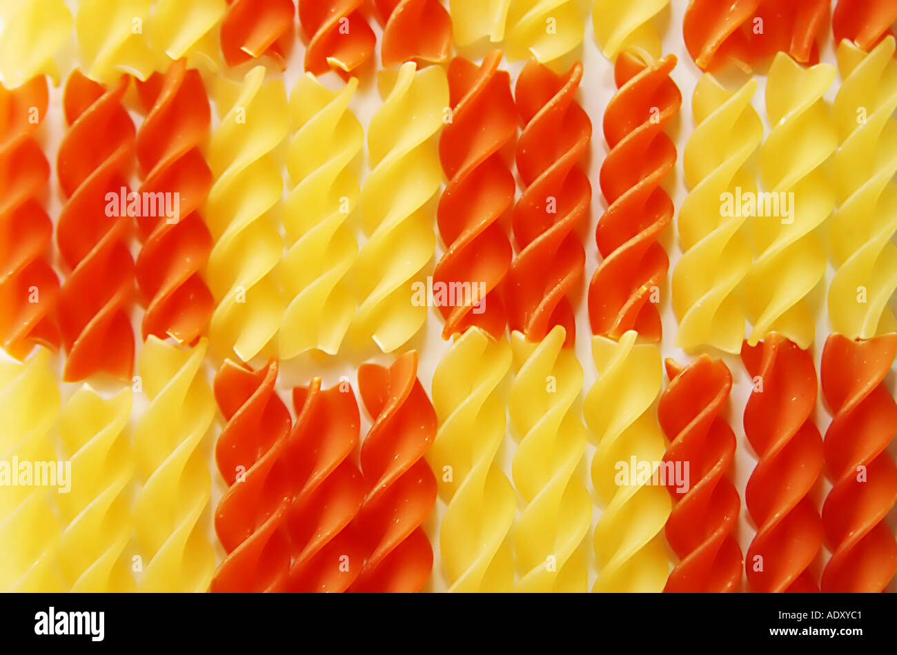 curly pasta in yellow and orange Stock Photo - Alamy