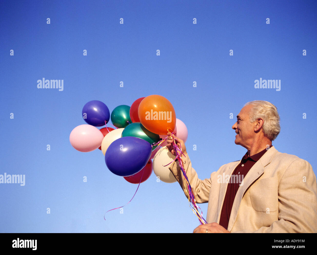 Man Holding Bunch of Balloons Stock Photo - Alamy