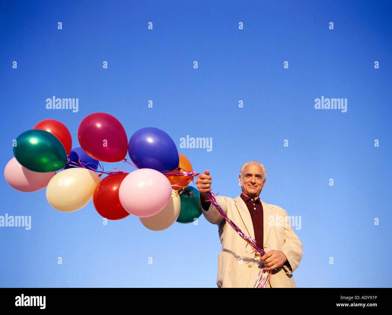 Man Holding Bunch of Balloons Stock Photo - Alamy