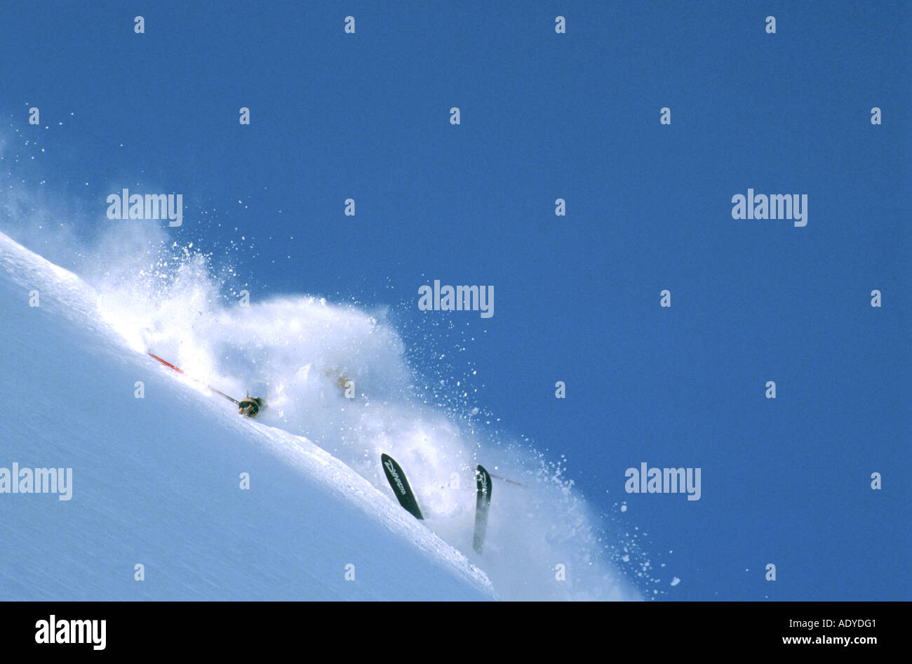 male skier, falling in steep slope, with blue sky in background Stock ...