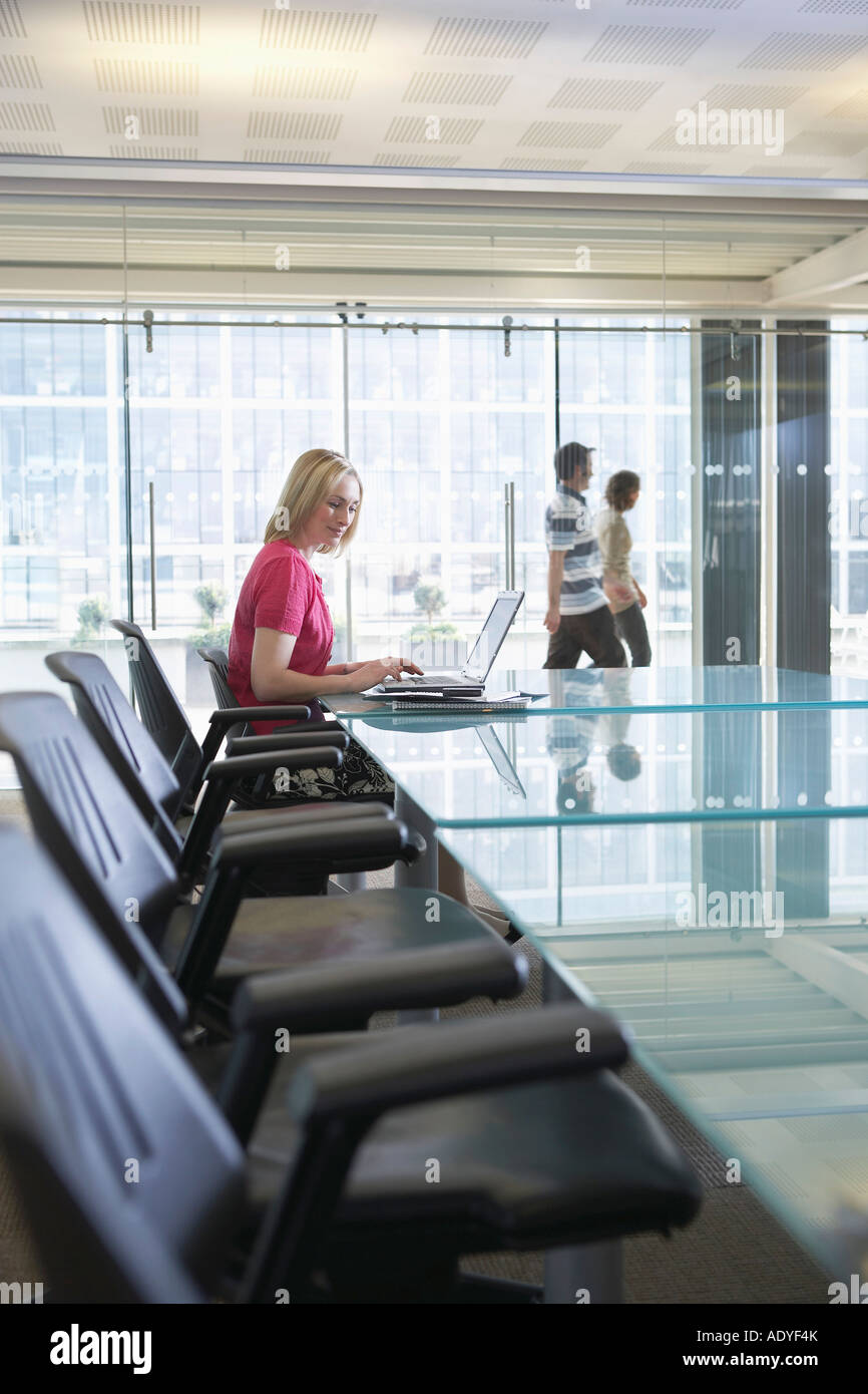 Office worker using laptop, sitting in conference room, side view Stock ...