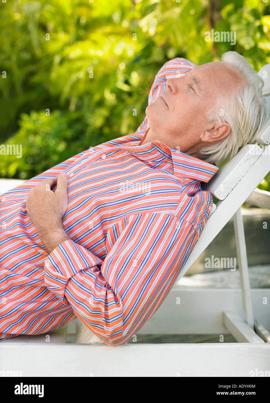 Man reclining on lounge chair outdoors, side view Stock Photo - Alamy