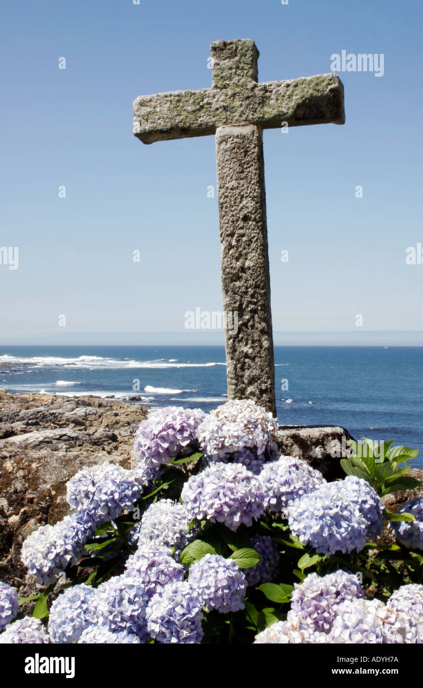Stone Cross with ocean backdrop flowers at base Stock Photo - Alamy
