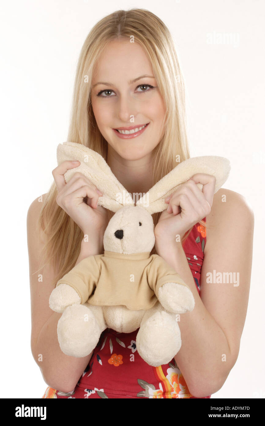 long-haired blonde woman holding toy rabbit at its ears Stock Photo - Alamy