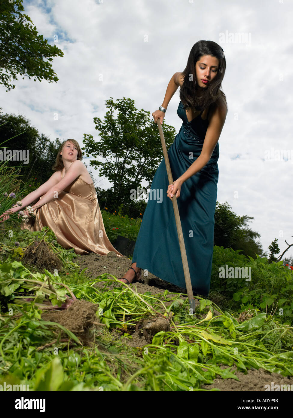 Two young women veg gardening in evening dress Stock Photo - Alamy
