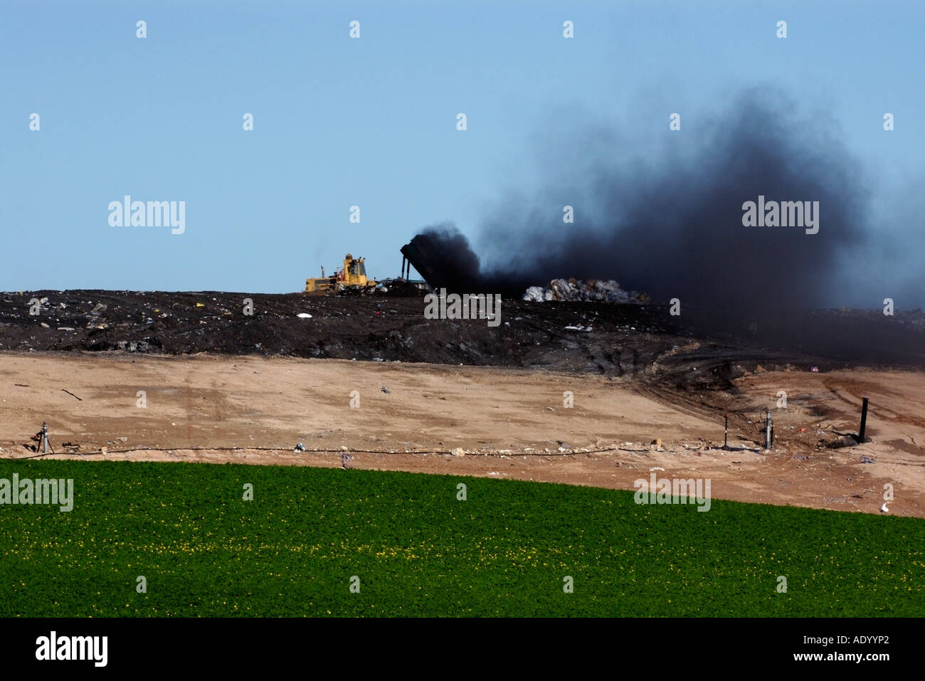 Cloud of black dust rising from load of waste material going into ...