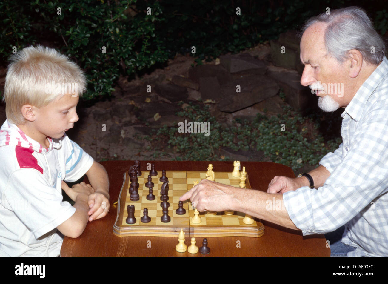 Grandfather and grandson playing chess Stock Photo - Alamy