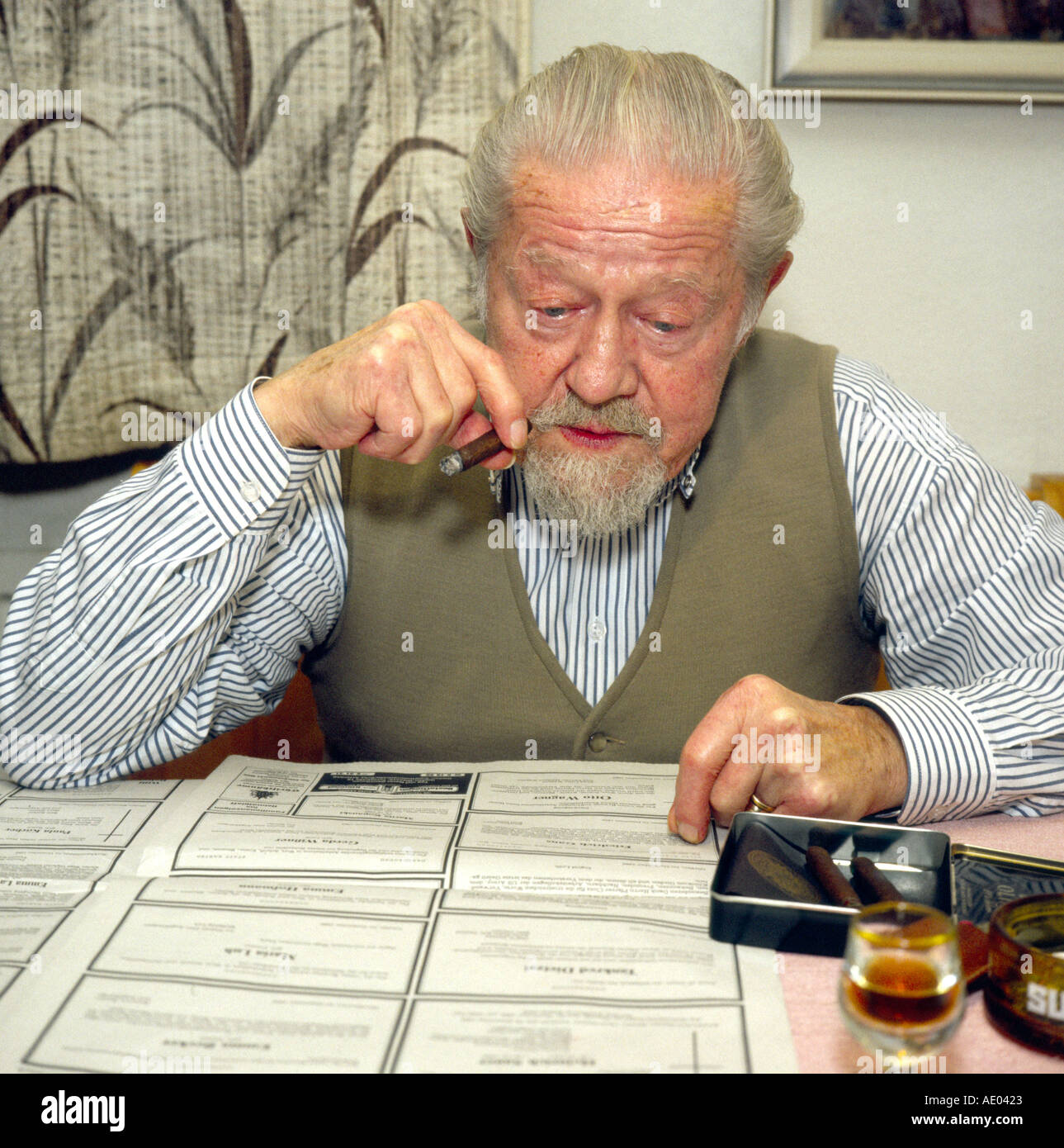 Old man reading death notices Stock Photo - Alamy