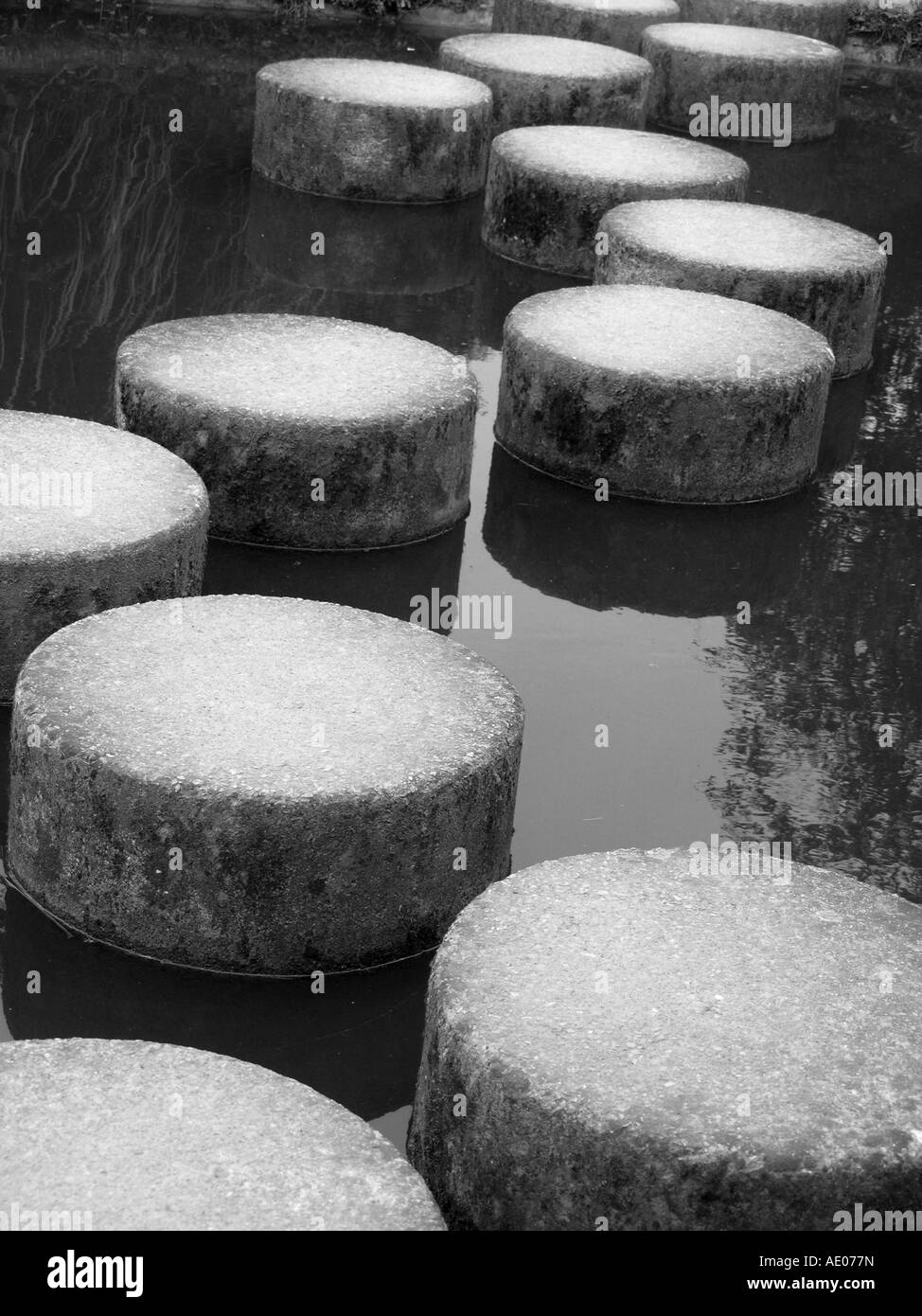 Mono image of round stepping stones in water Stock Photo - Alamy