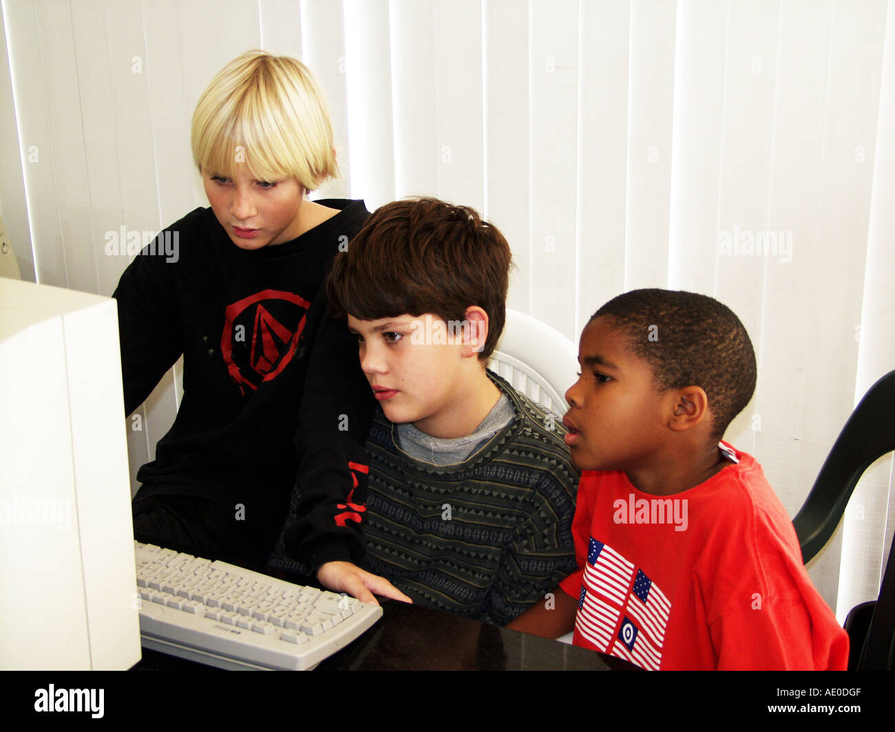 Three multicultural young boys enjoy computer games. USA Stock Photo ...