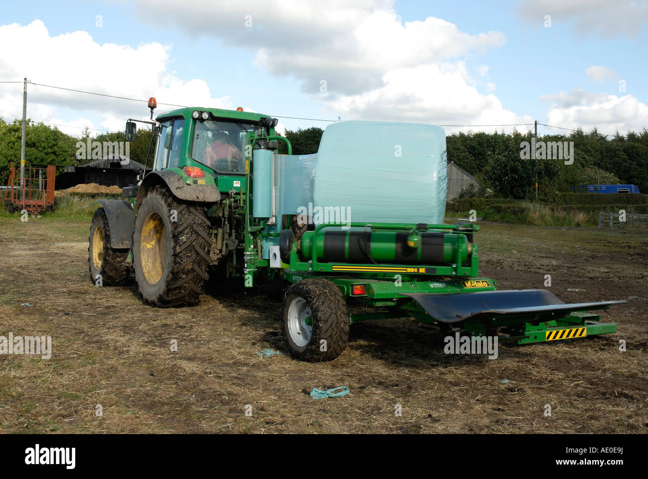 Wrapping round bales of hay for Haylage Stock Photo - Alamy