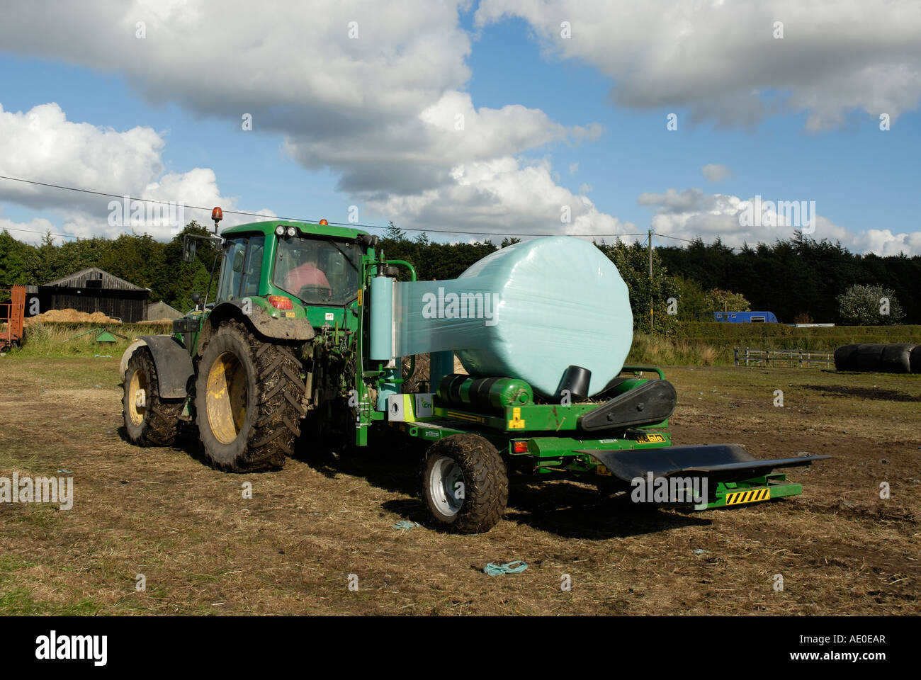 Wrapping round bales of hay for Haylage Stock Photo - Alamy