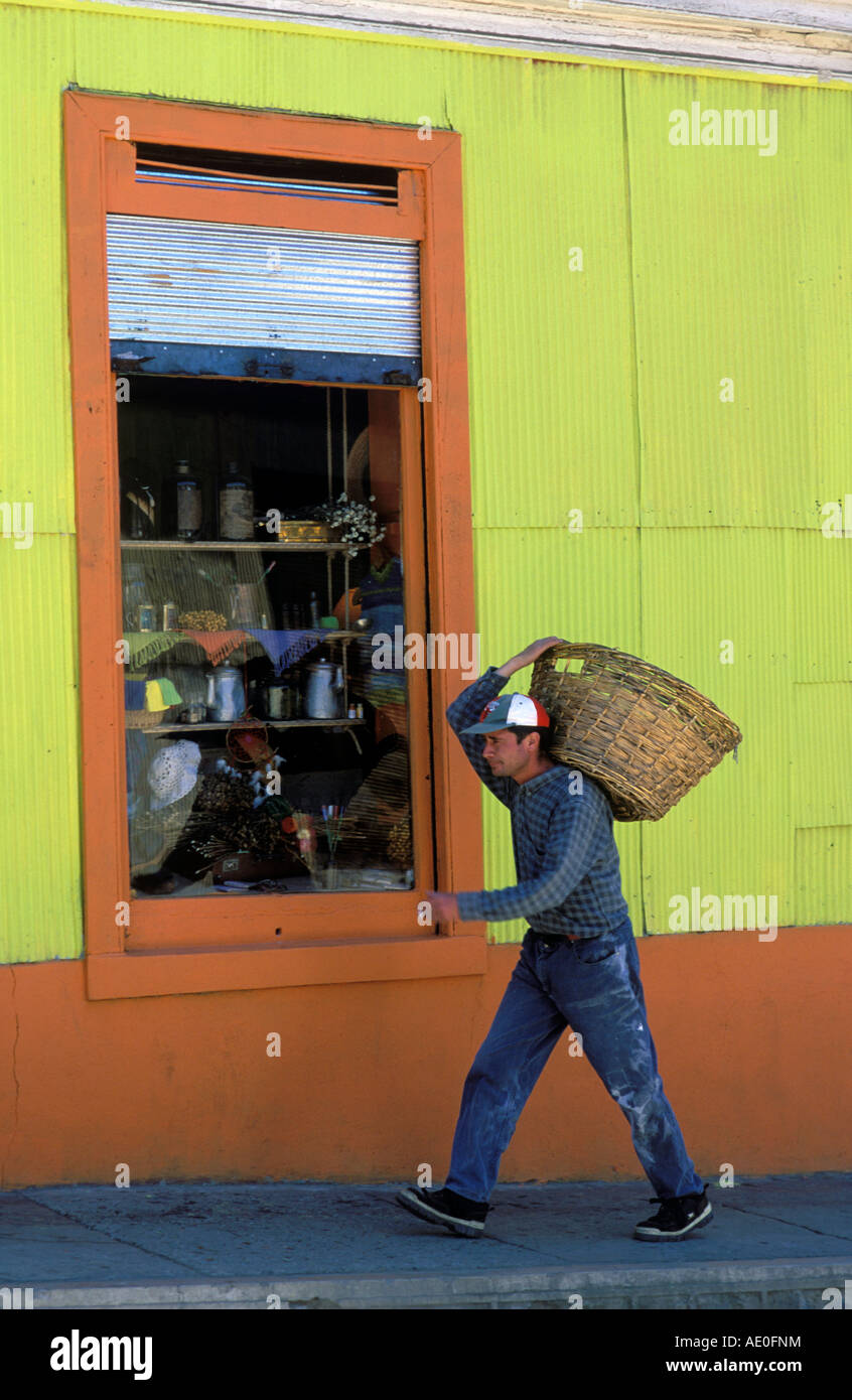 A man carrying a wicker basket walks past a junk shop window in Cerro ...