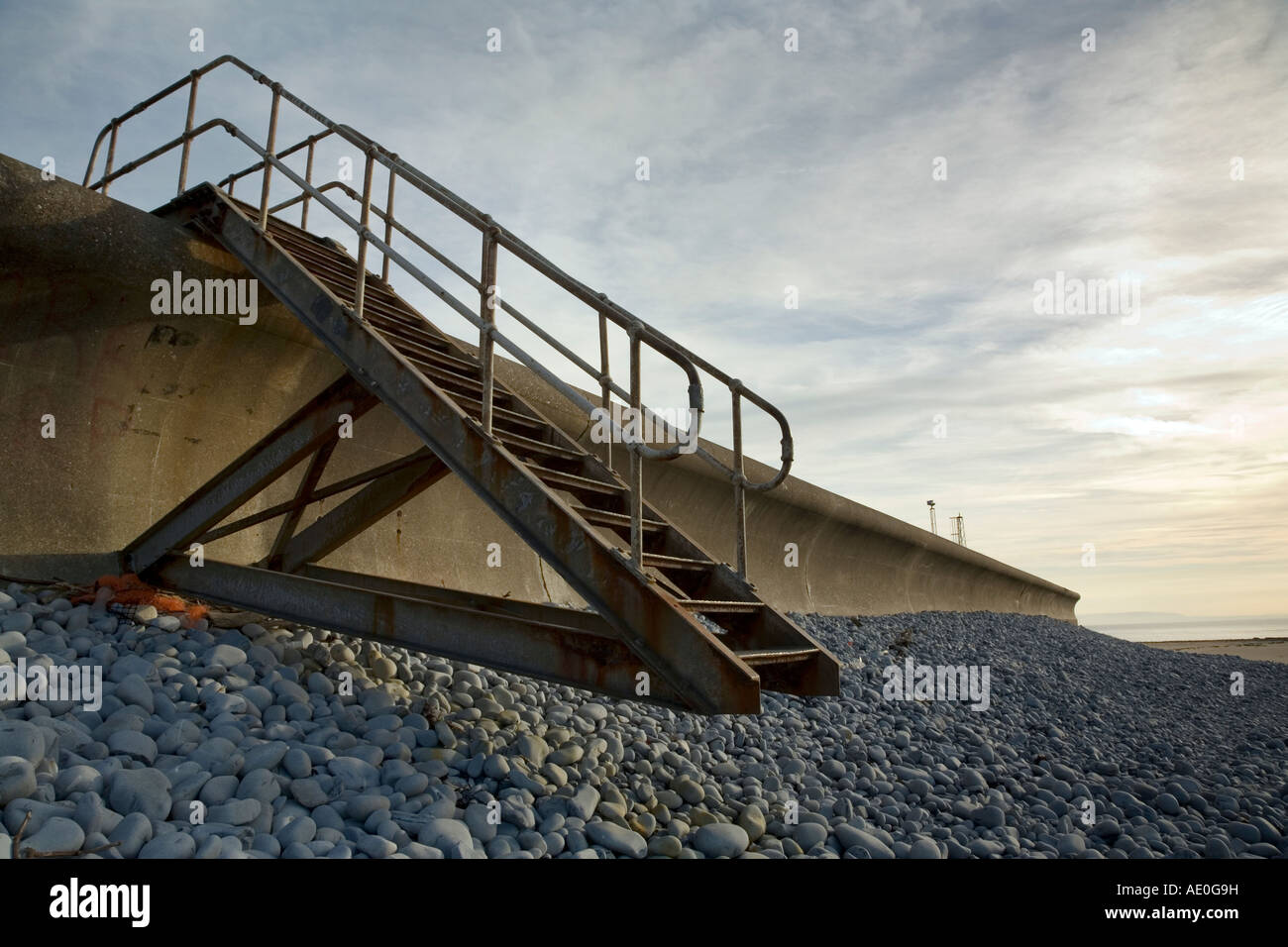 Concrete sea defence wall with iron stairway no longer reaching the ...