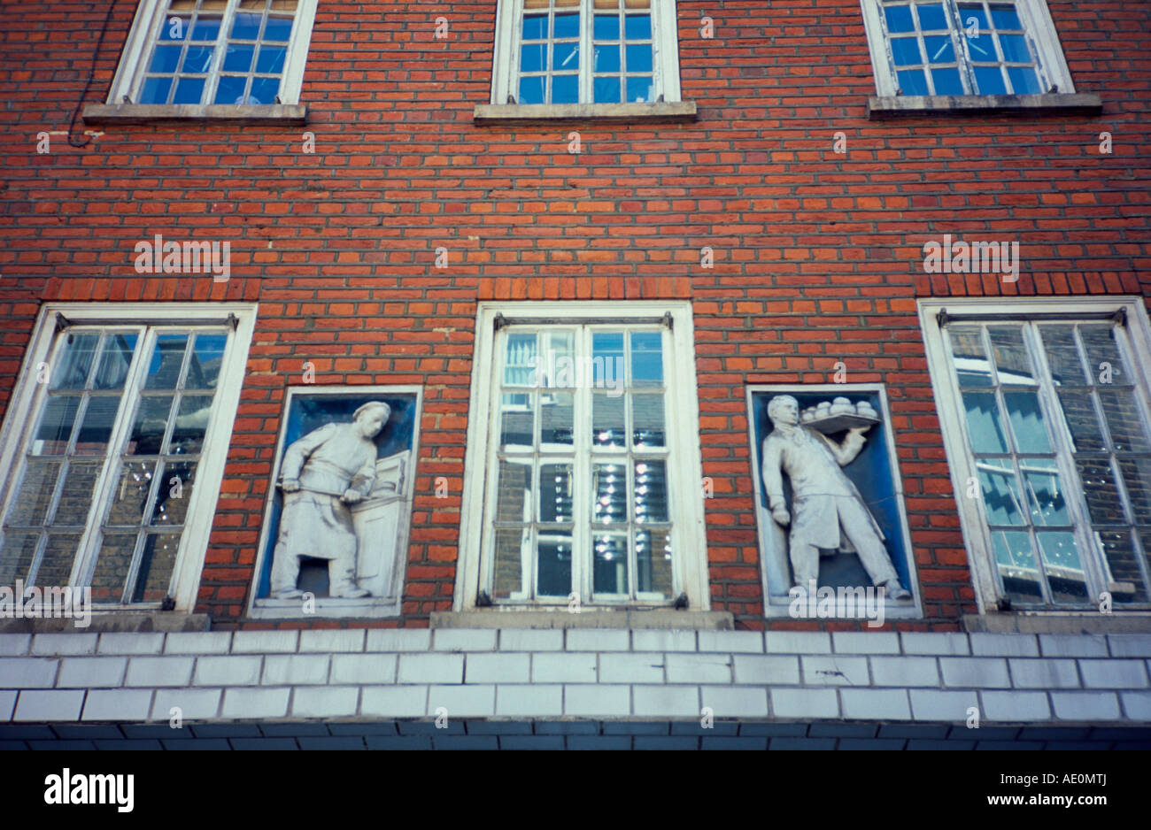 Trade decorations on a wall above a shop London E1, UK Stock Photo - Alamy