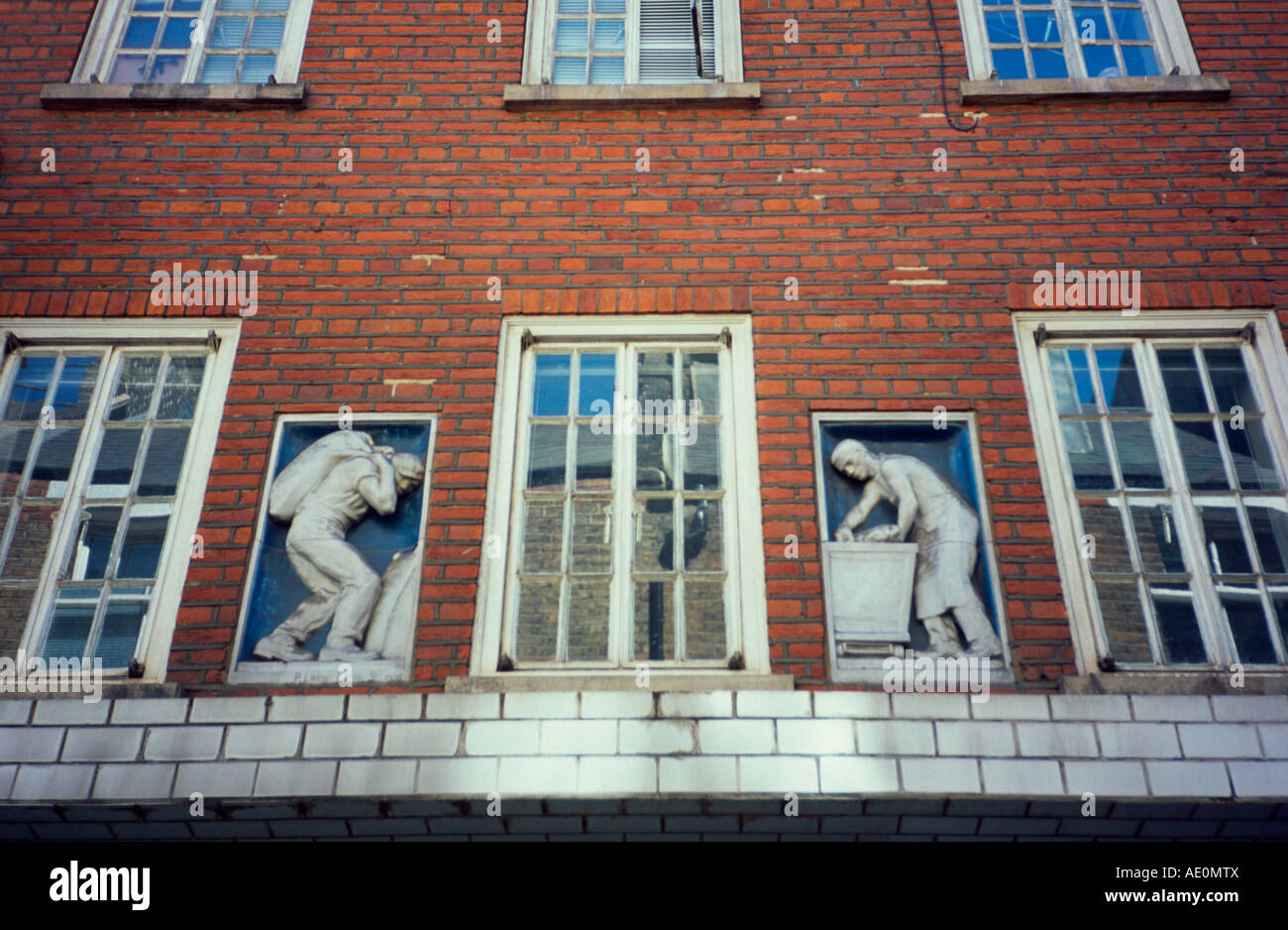 Trade decorations on a wall above a shop London E1, UK Stock Photo - Alamy