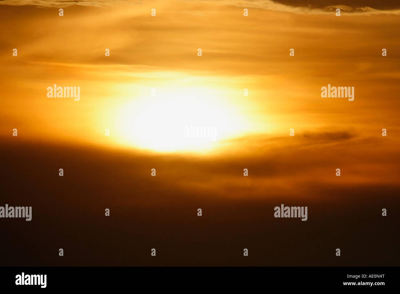 Sunset behind clouds Stock Photo - Alamy