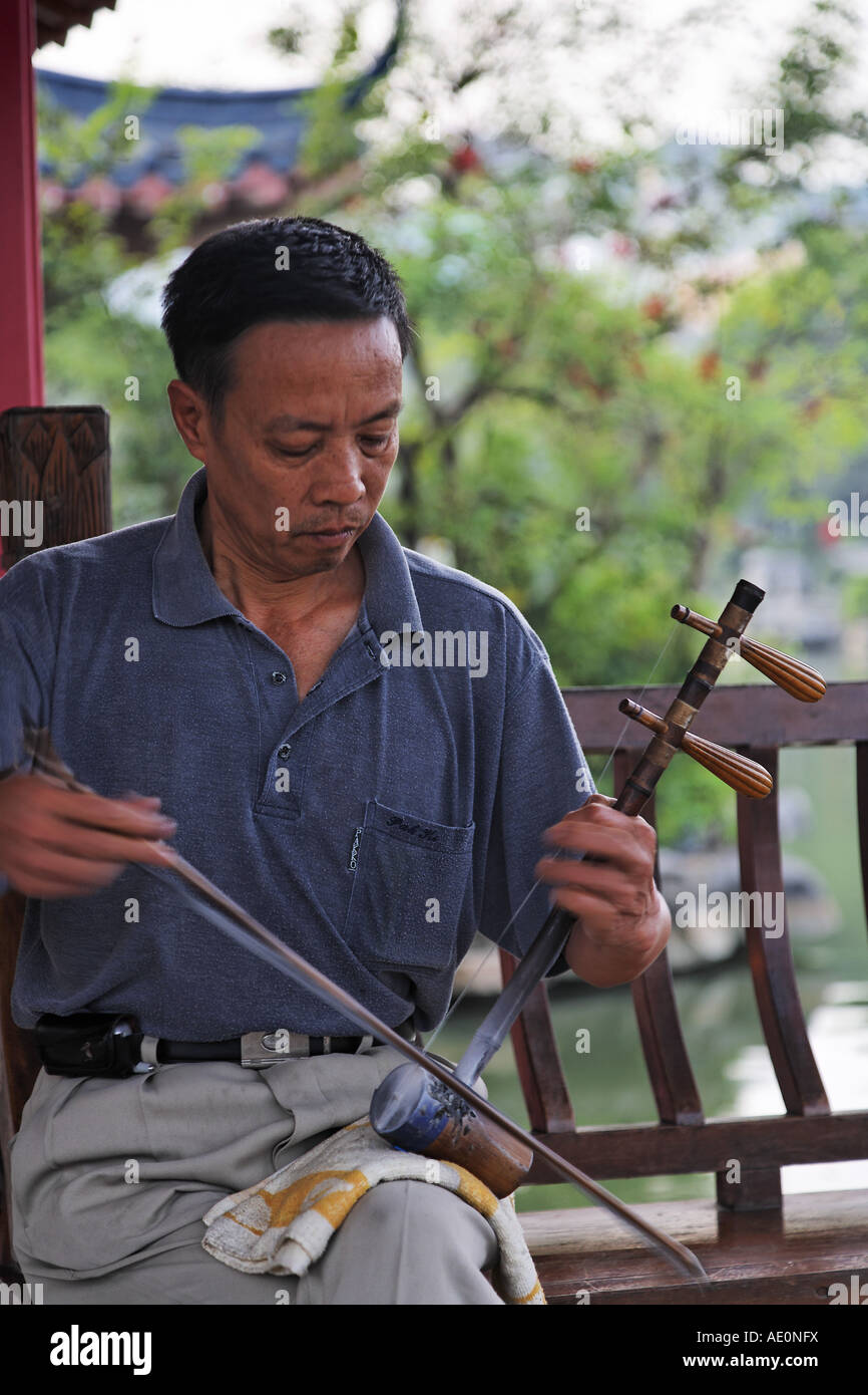 A man playing the Chinese opera fiddle in a park Rong Lake Guilin China ...