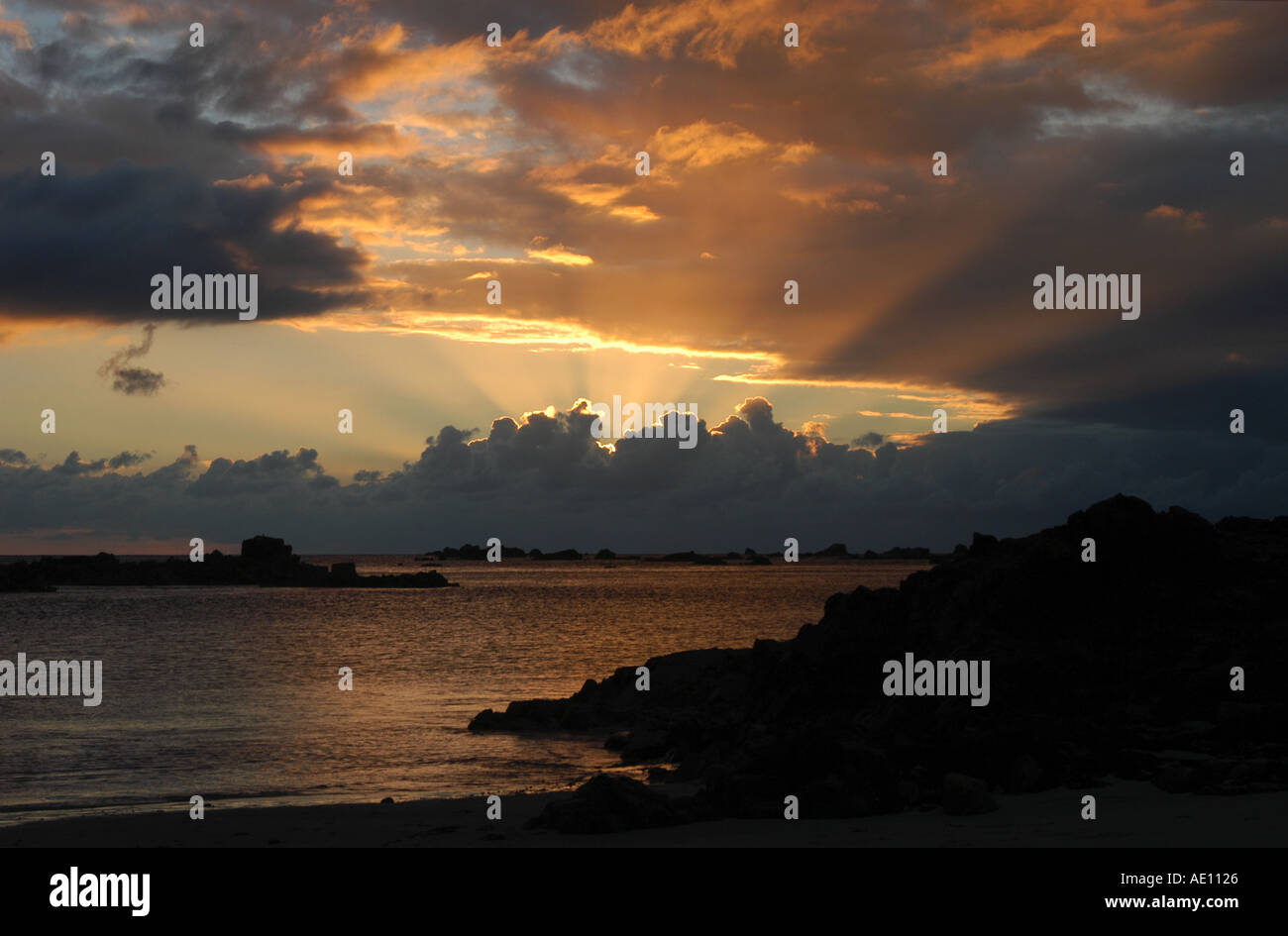 Multi coloured surreal sunset over the sea and rocks Stock Photo - Alamy