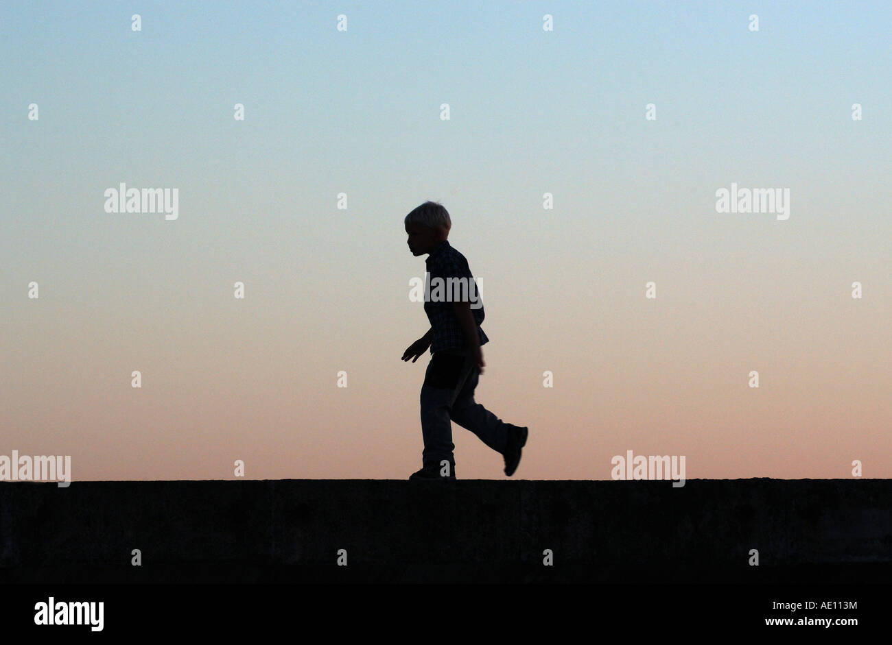 Silhouette of a running boy in the evening Stock Photo - Alamy