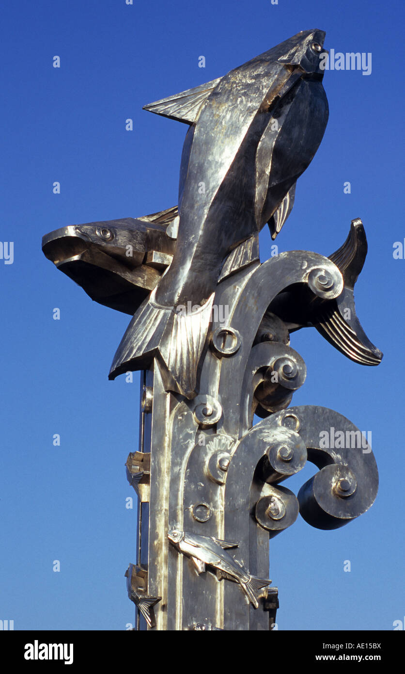 Bronze metal fish sculpture in riverfront park gardens mid afternoon ...