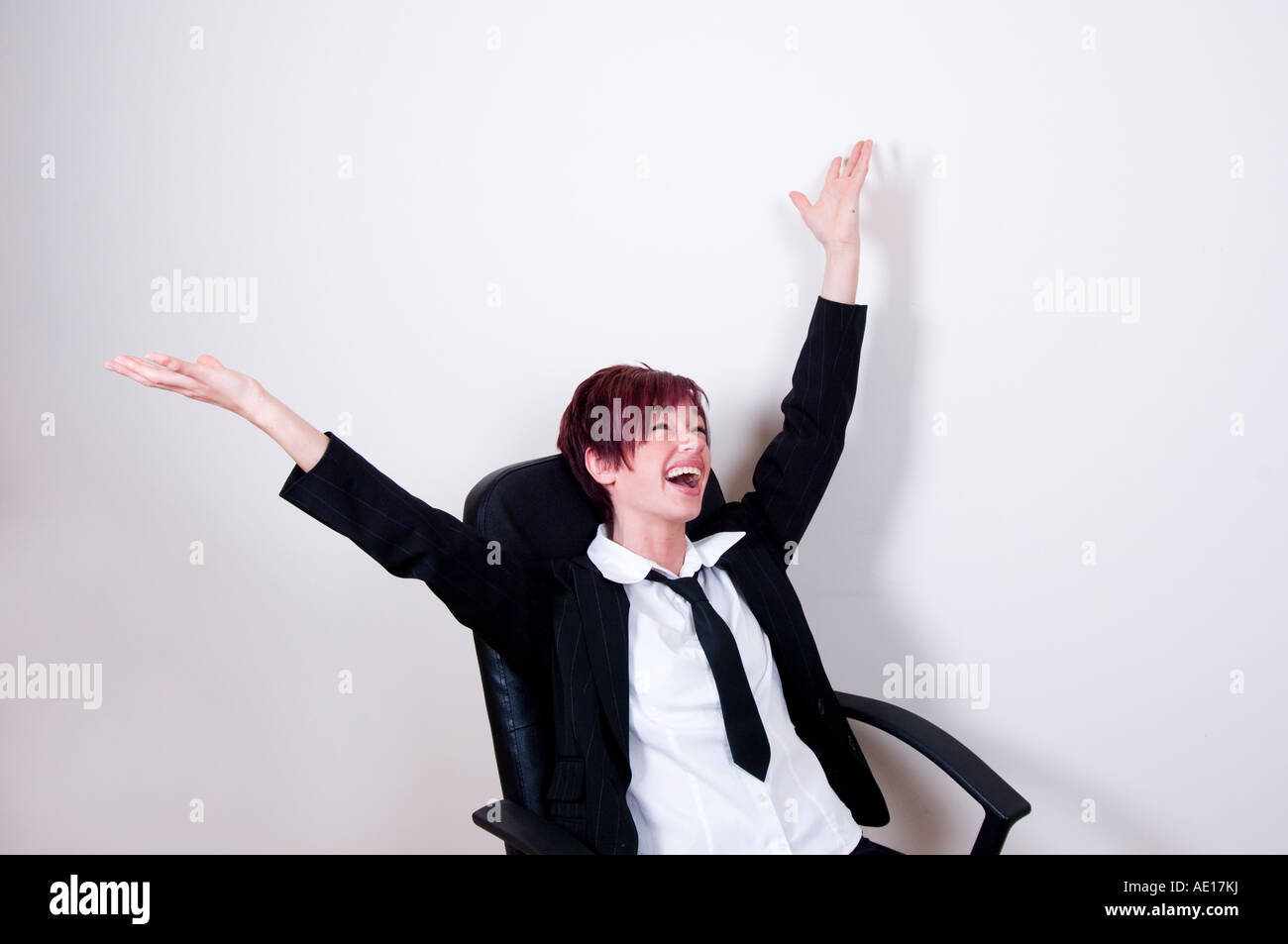 Happy businesswoman sitting on chair hands up Stock Photo - Alamy