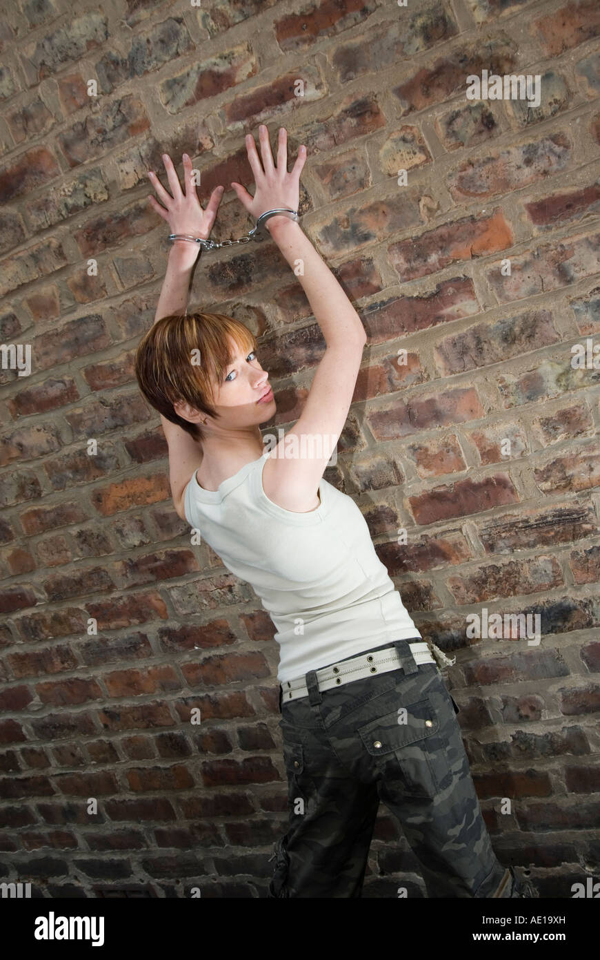 Handcuffed woman against the wall Stock Photo - Alamy