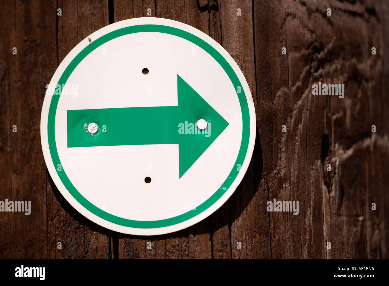 Green arrow sign on wooden pole pointing right Stock Photo - Alamy