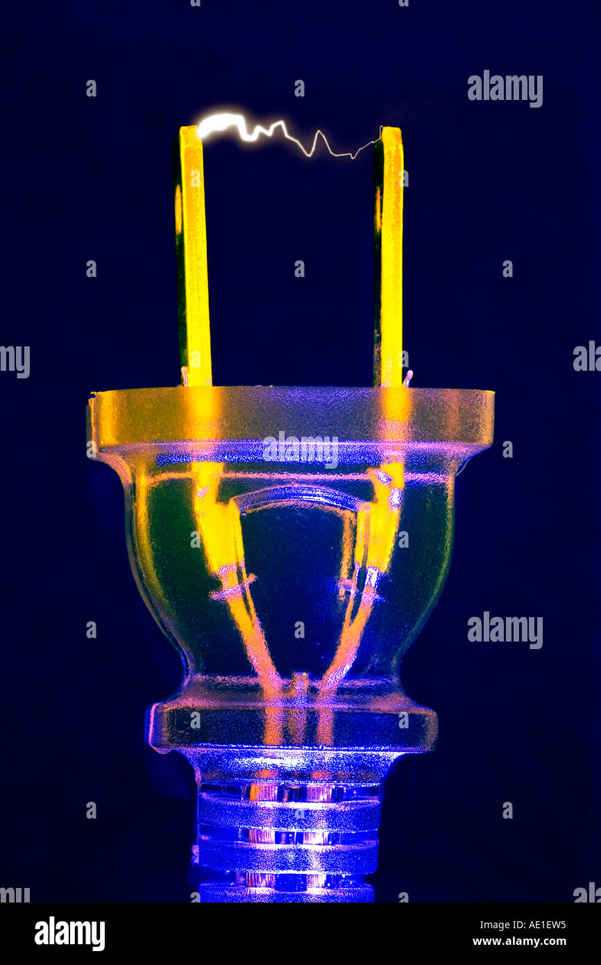 Clear blue pink and yellow electric plug against a dark blue background ...