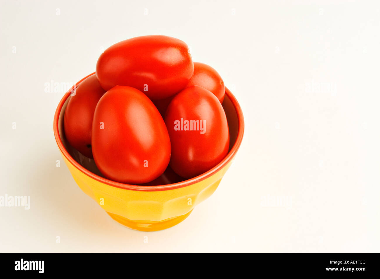 Roma Tomatoes in a yellow bowl Stock Photo - Alamy