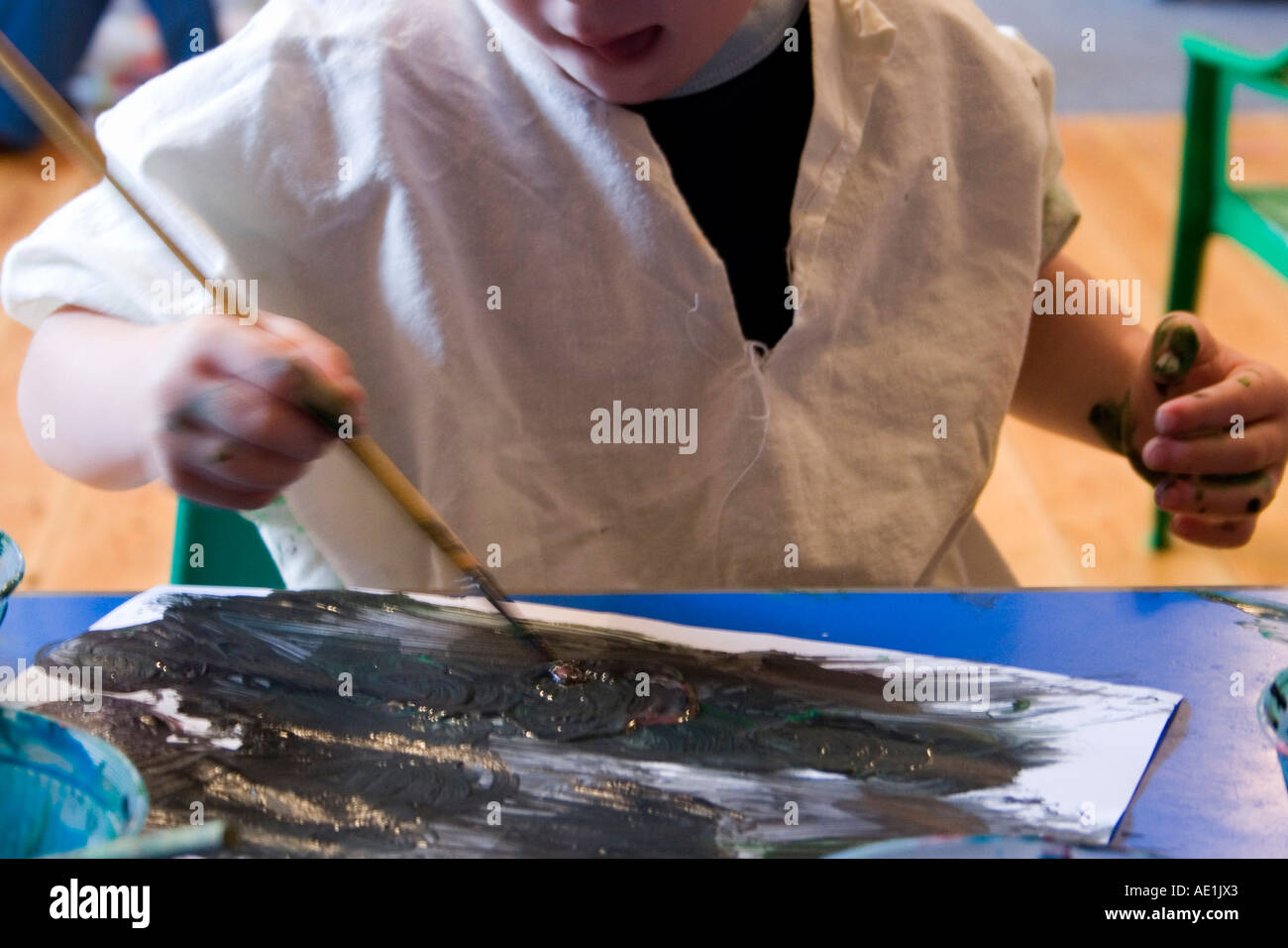Small boy painting at play school Stock Photo - Alamy
