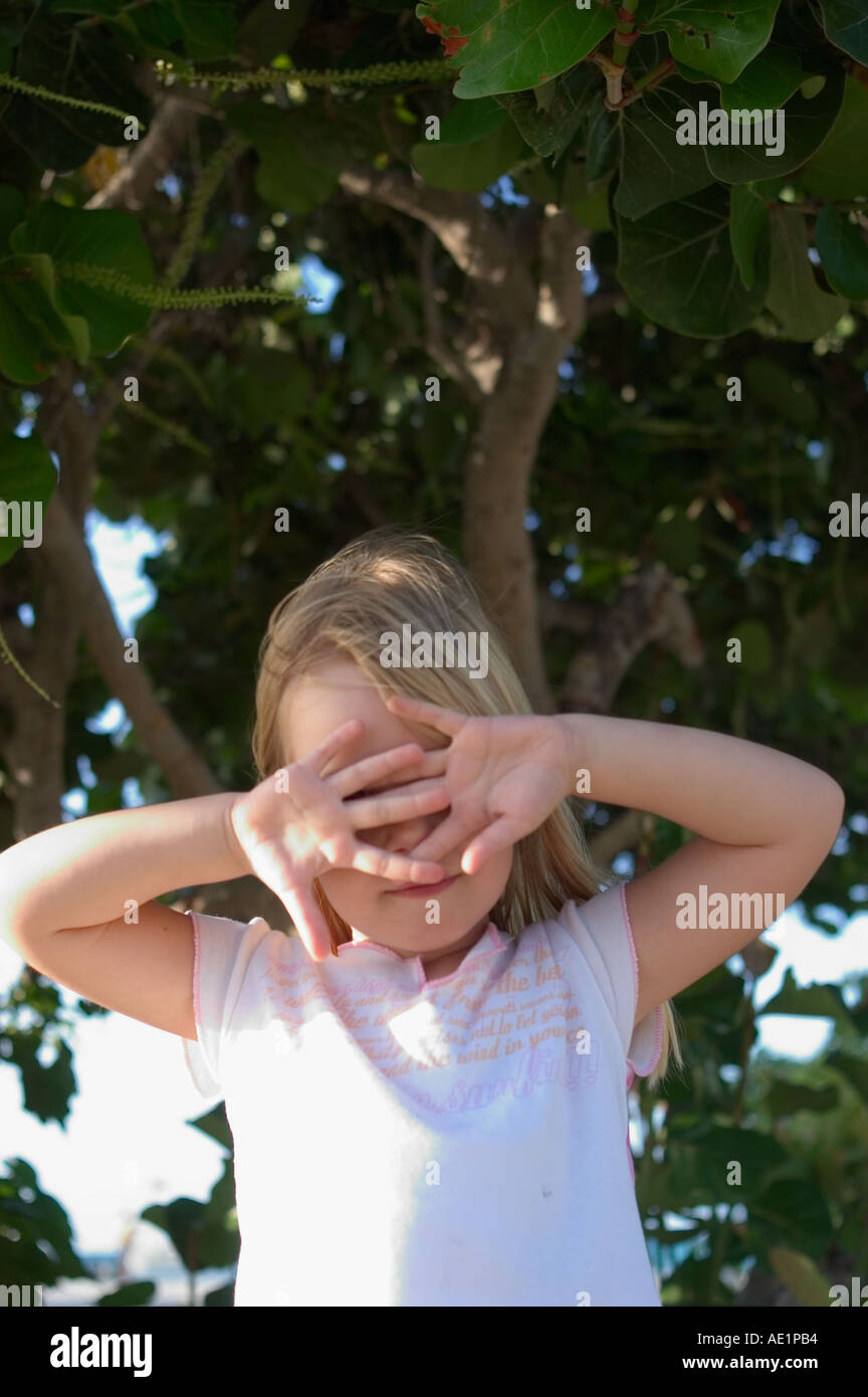 A playful little girl beside a tree Stock Photo - Alamy