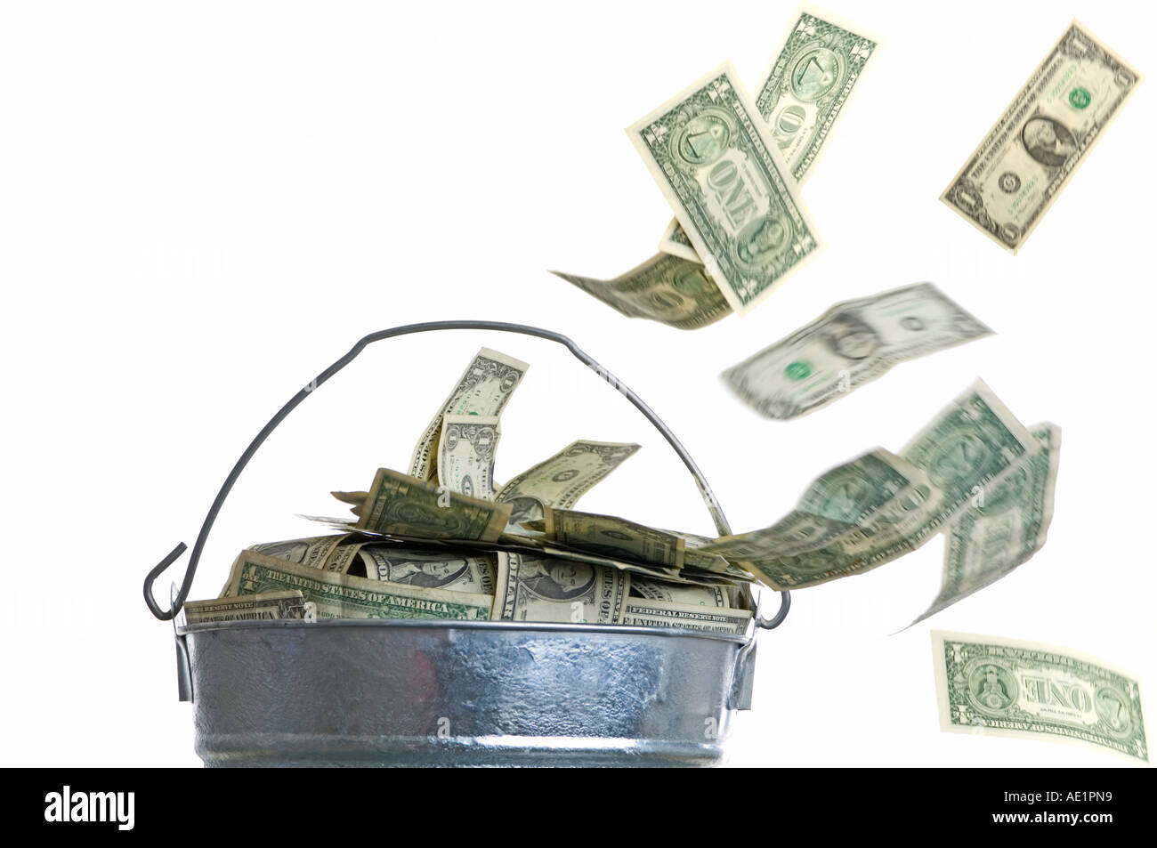 one dollar bills falling into metal bucket Stock Photo - Alamy