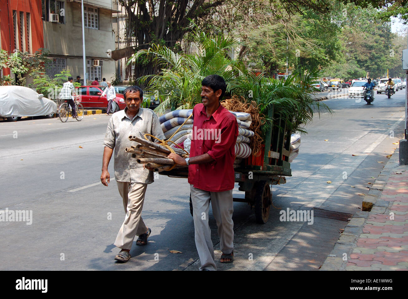 Two men pulling hand cart in typical street scene in Mumbai / Bombay ...