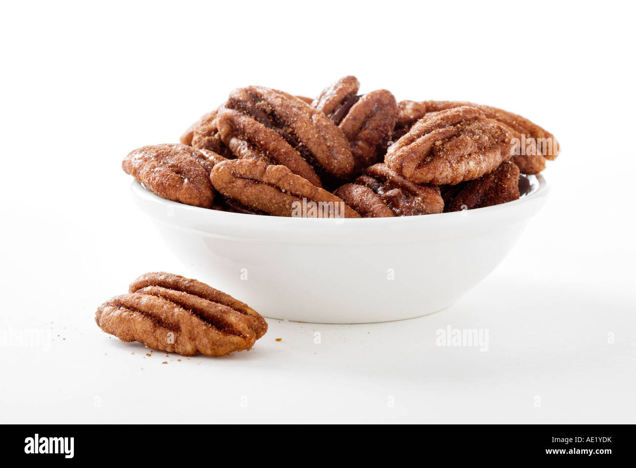 A bowl of cinnamon spiced pecans with white background cutout Stock ...