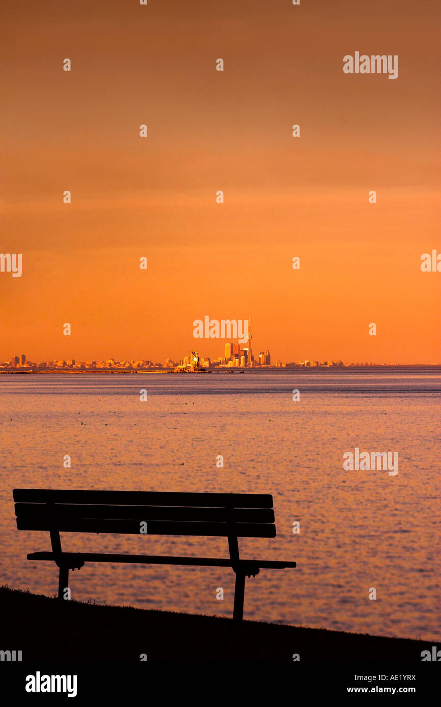 Empty bench overlooking the lake or ocean during sunset or sunrise. Far ...