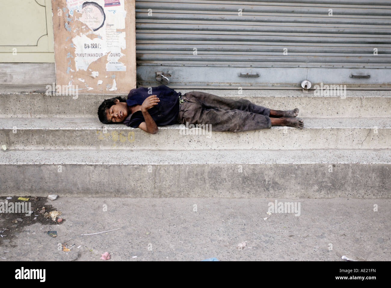 Homeless boy asleep on street Stock Photo - Alamy