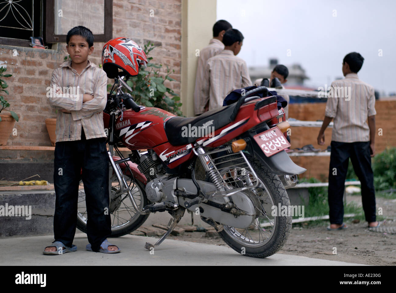 Boy standing by a motorbike Stock Photo - Alamy