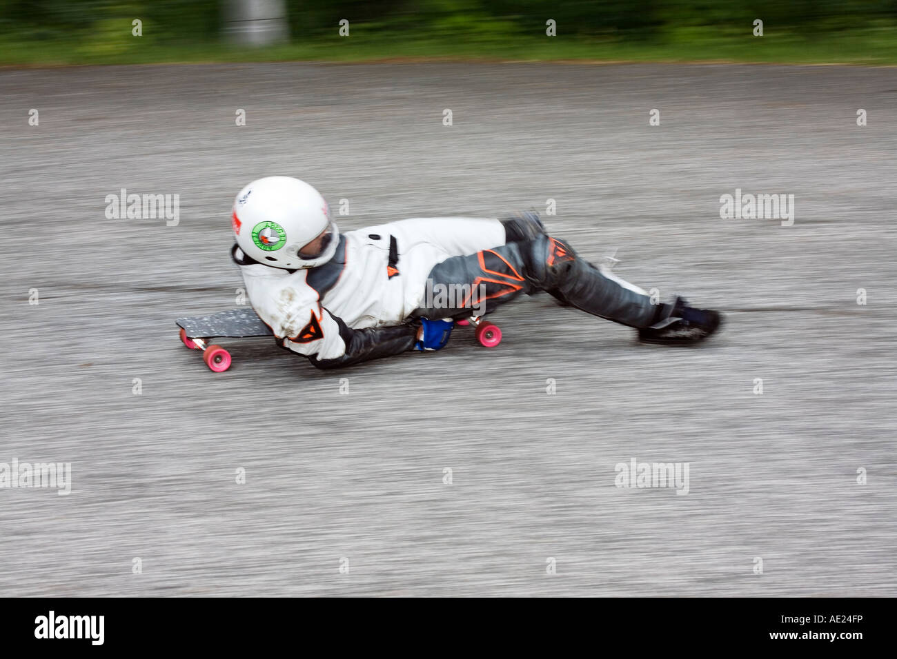 A man riding Butt board Longboard Skateboard on Downhill competition on ...