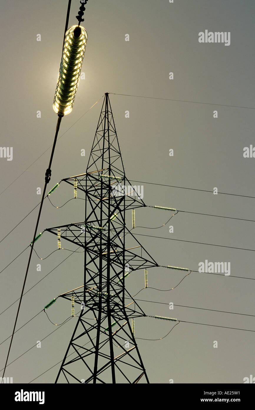 electricity pylon insulator with tower in background Stock Photo - Alamy