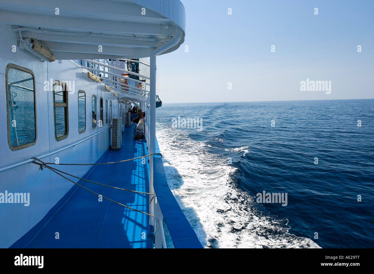 The left side deck of a white ship with blue floor View of the ship and ...