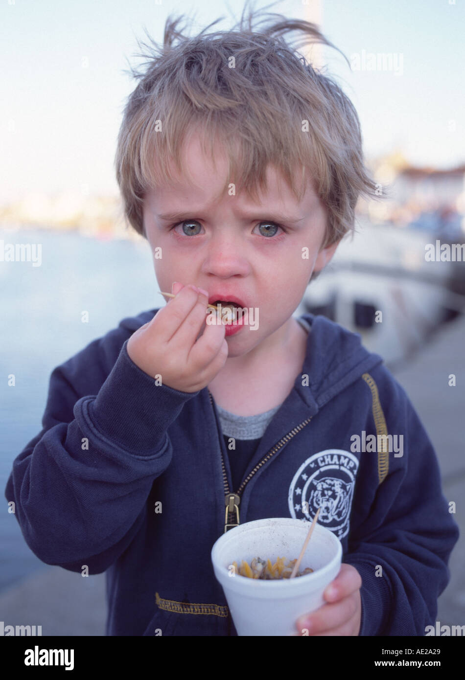 boy eating cockles from plastic cup at the seaside Stock Photo - Alamy
