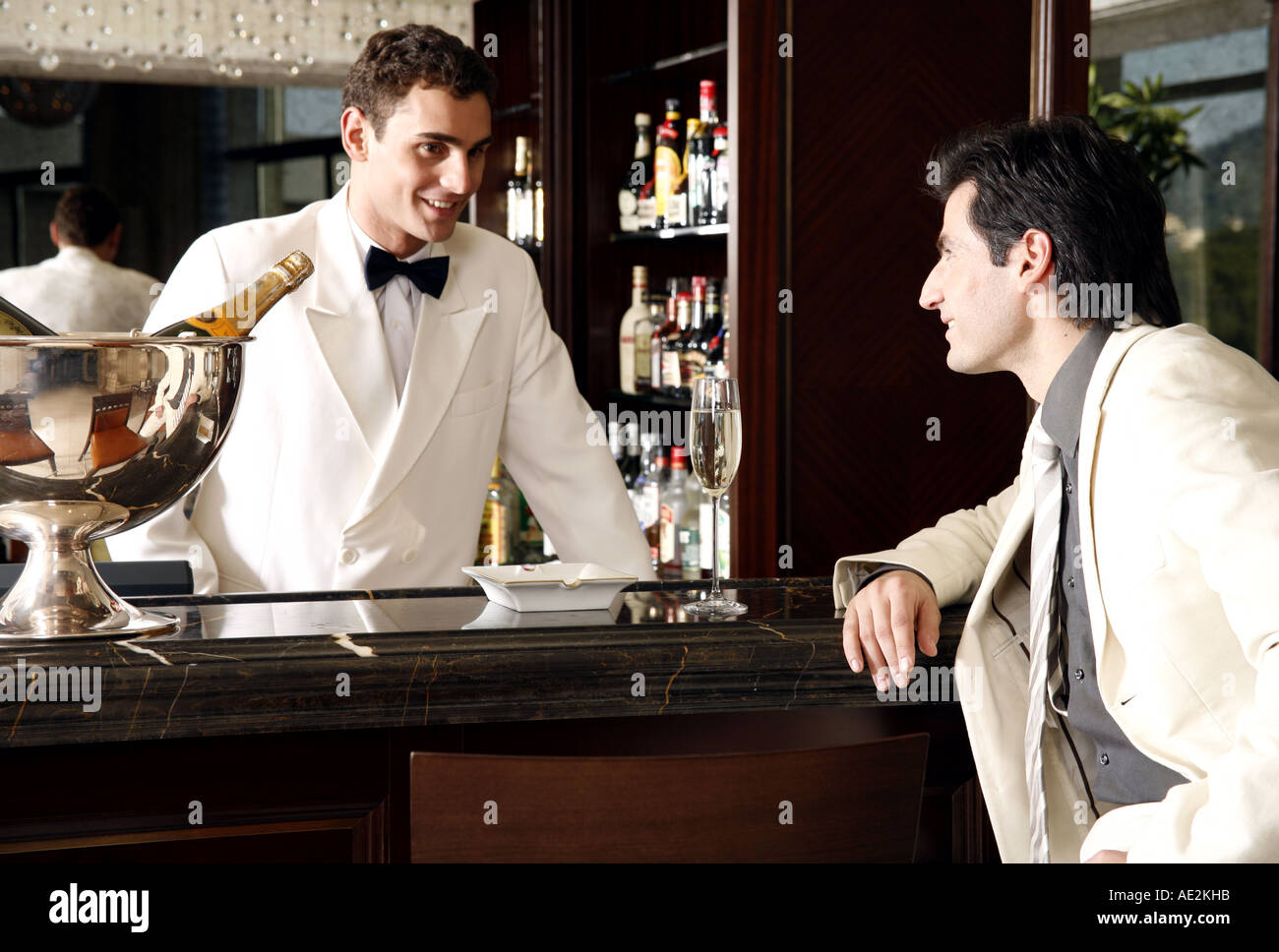 Man sitting at a bar talking to the bartender Stock Photo - Alamy