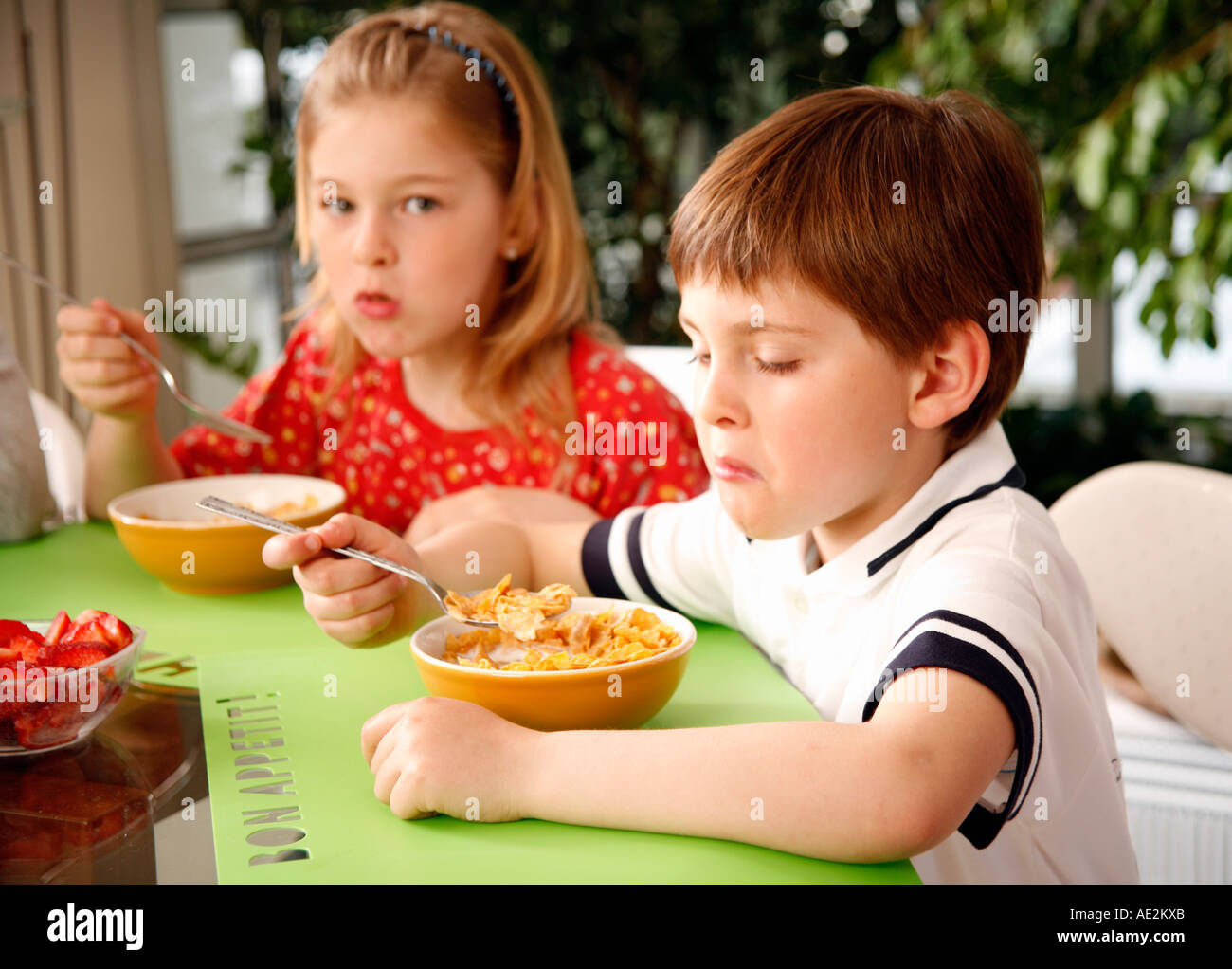 Mother and children eating breakfast Stock Photo - Alamy
