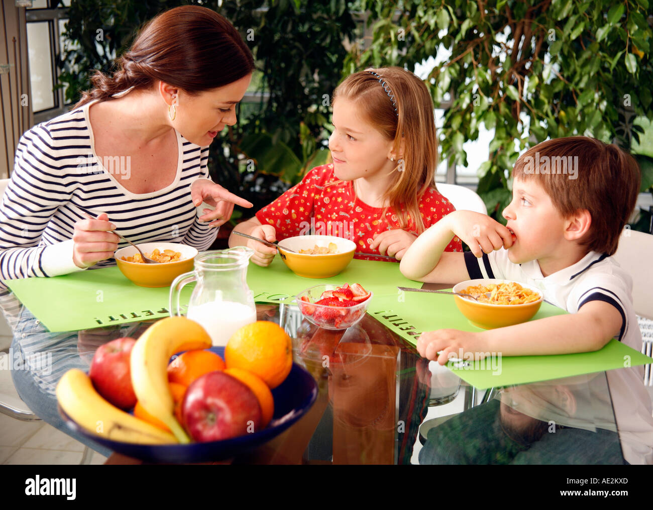 Mother and children eating breakfast Stock Photo - Alamy