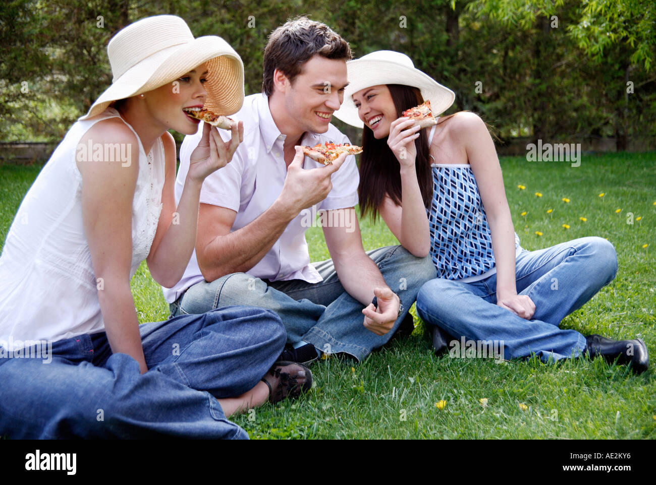 Three friends eating pizza Stock Photo - Alamy