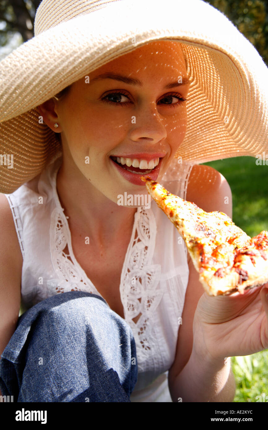 Young woman eating pizza Stock Photo - Alamy